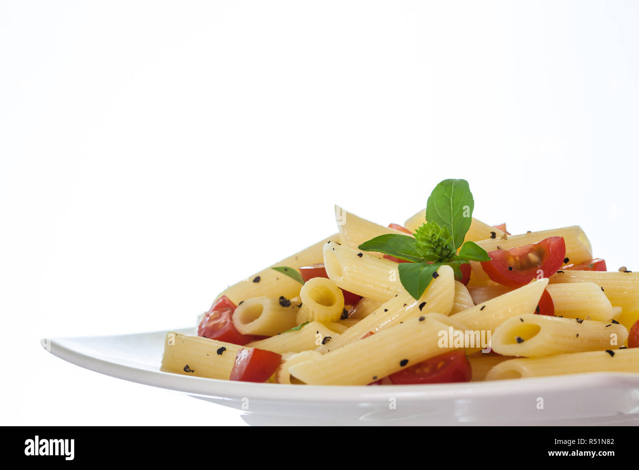 Penne rigate with cherry tomatoes and black pepper on white background ...