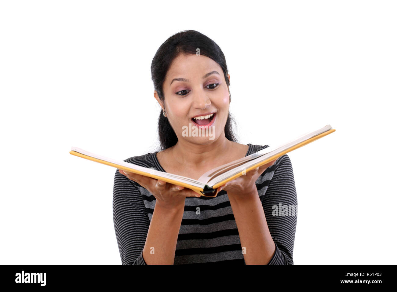 Excited young woman reading a book Stock Photo - Alamy