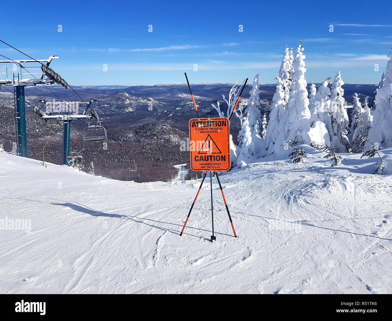 Caution sign and warning on a ski resort about unmarked rocks and ...