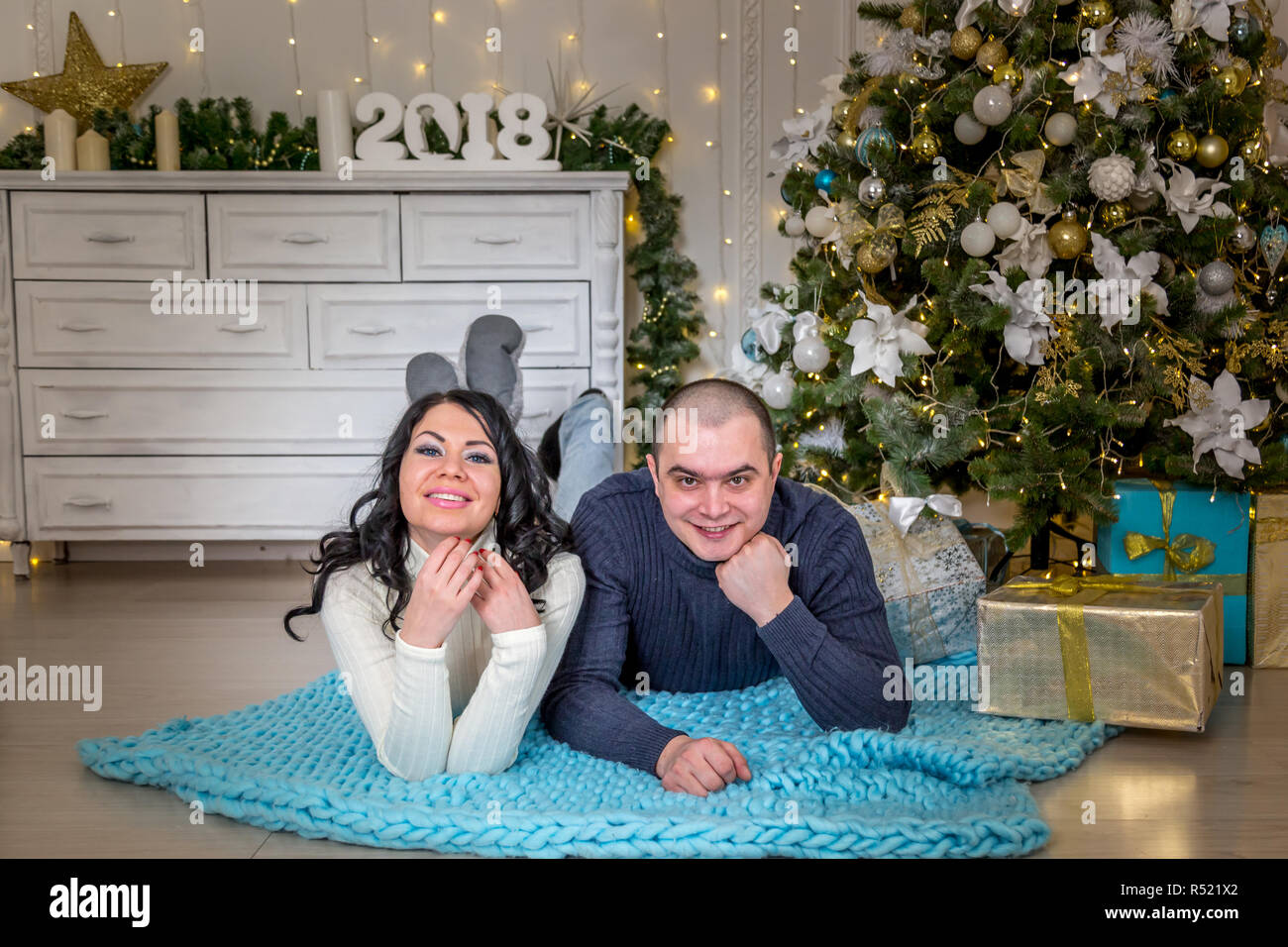 Young couple in love on a blue plaid on the background of a decorated ...