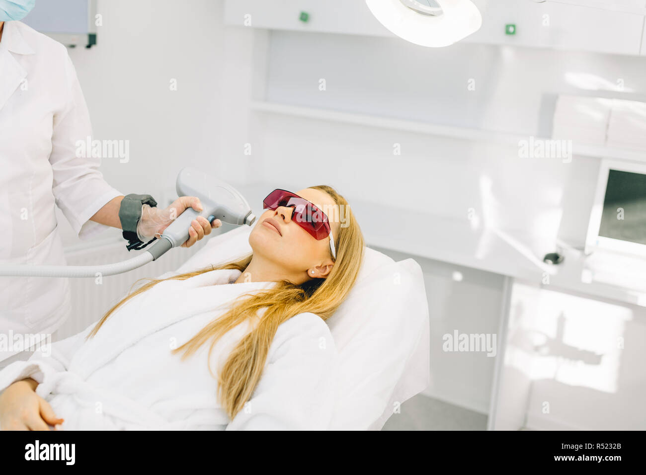 Woman getting laser and ultrasound face treatment in medical spa center ...