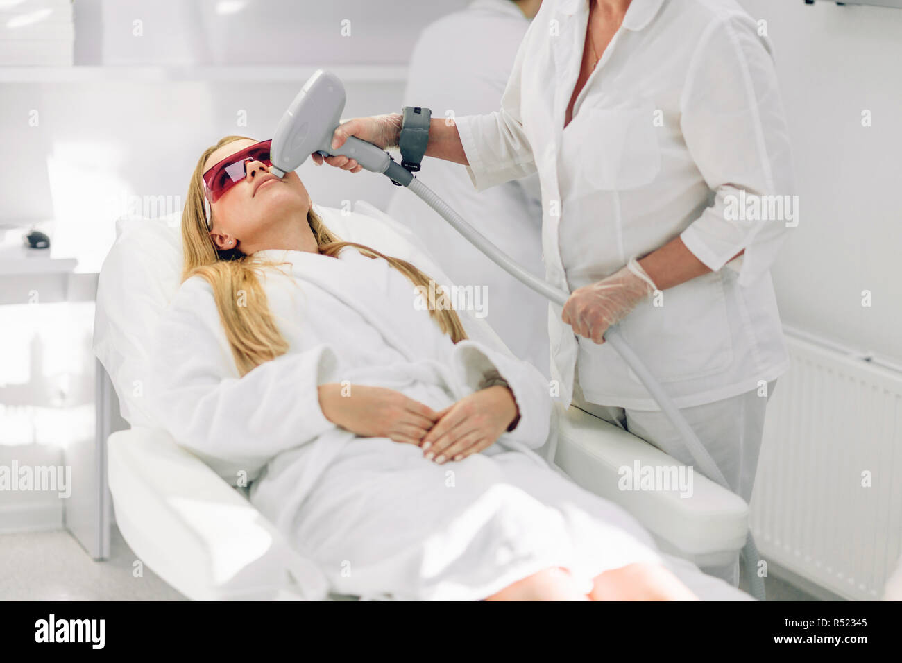 Woman getting laser and ultrasound face treatment in medical spa center ...