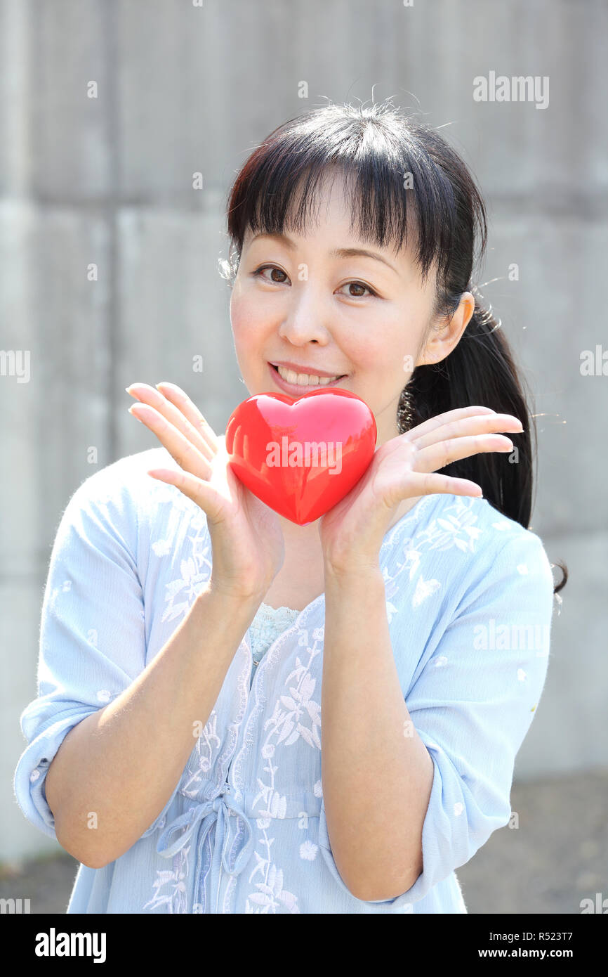 Portrait of young japanese woman hand holding red heart Stock Photo - Alamy