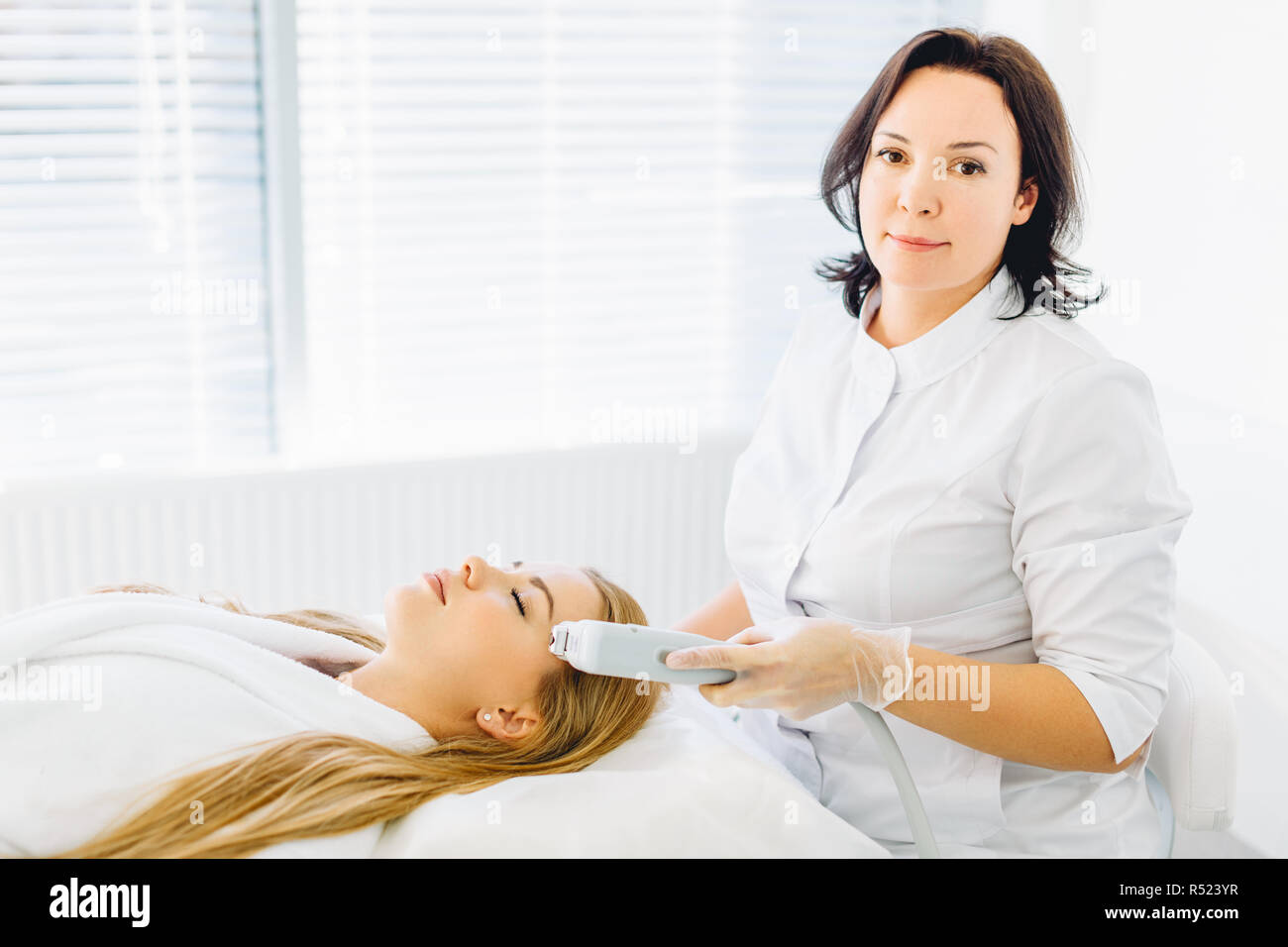 Face skin care. Woman getting facial laser treatment Stock Photo - Alamy