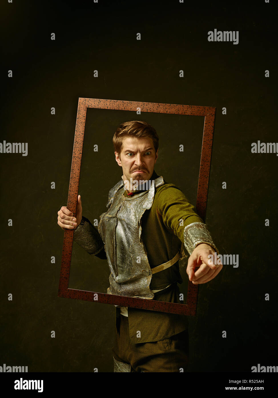 Medieval angry knight on dark studio background. Portrait in low key of ...