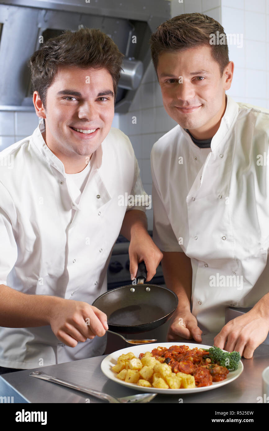 Portrait Of Chef Instructing Trainee In Restaurant Kitchen Stock Photo ...