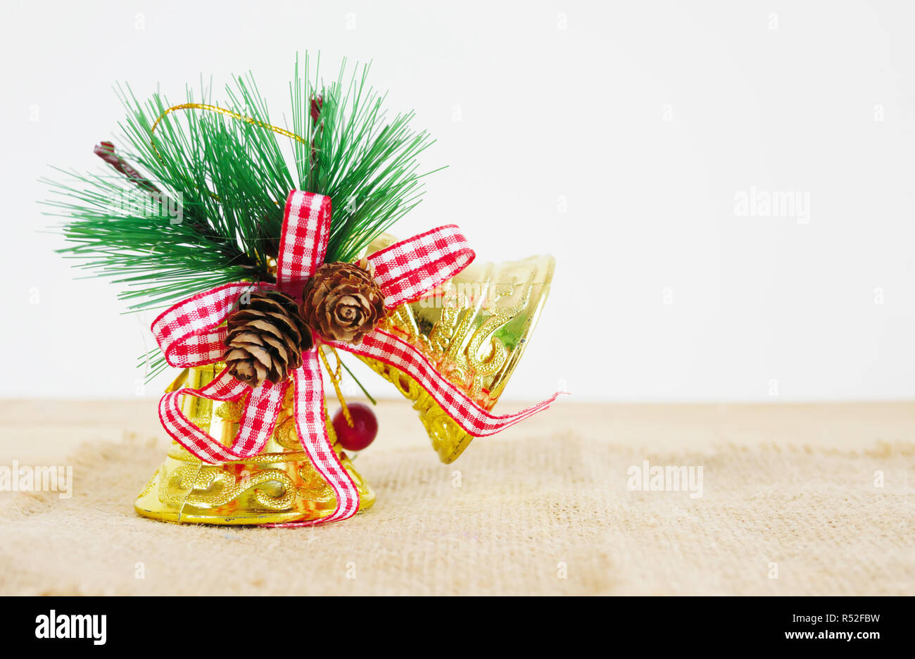 Golden bells christmas with red ribbon and pines on the brown sack and ...