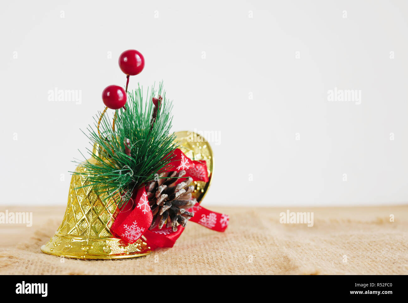 Golden bells christmas with red ribbon and pines on the brown sack and ...