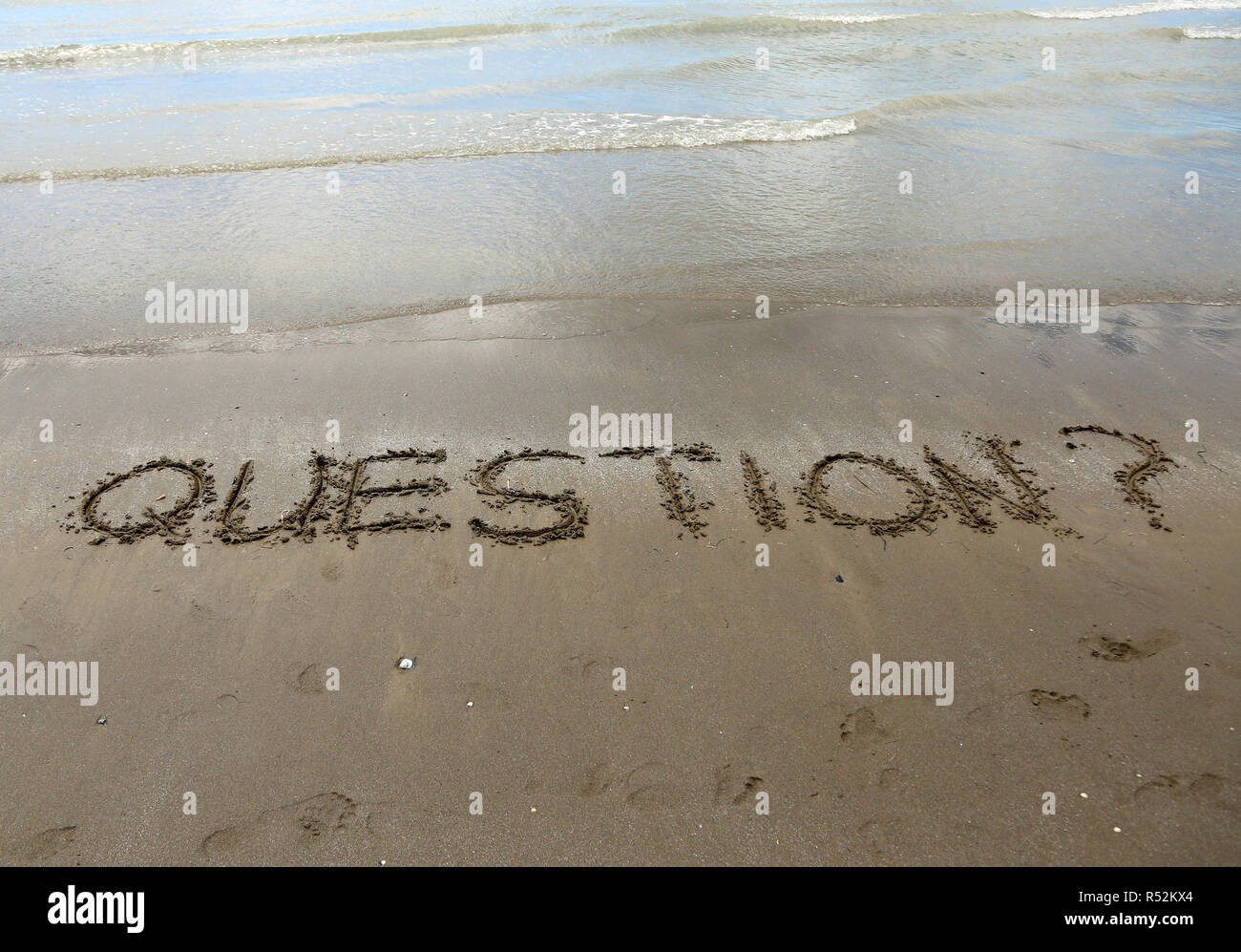 big text QUESTIONS on the beach sand by the sea Stock Photo - Alamy