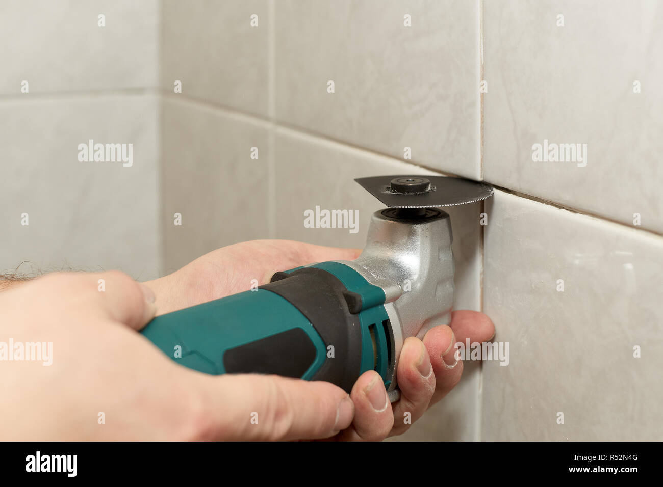 Male worker tiling a wall Stock Photo - Alamy