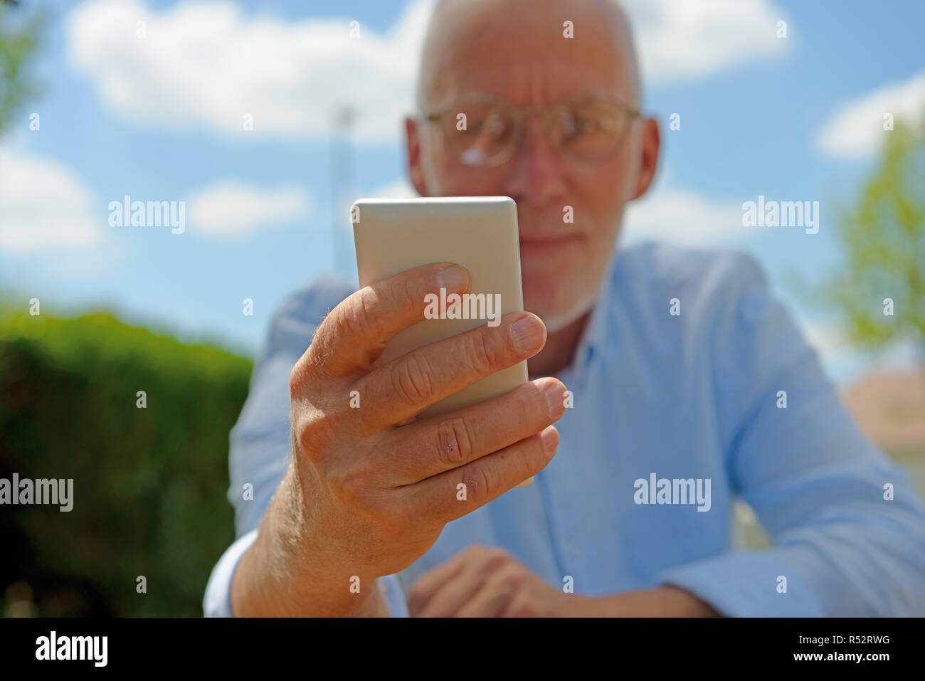 Candid older man looking smartphone hi-res stock photography and images ...