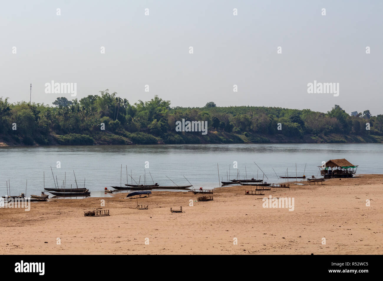Boats parked on a sandy beach on Don Daeng island on the Mekong river ...