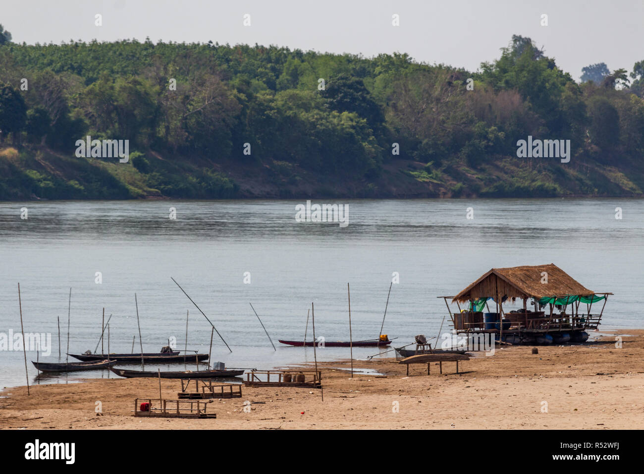 Boats parked on a sandy beach on Don Daeng island on the Mekong river ...