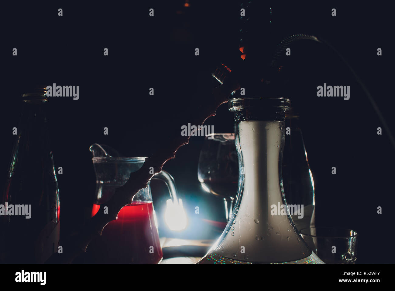 Group of black hookahs shisha on evening city background, blurred bokeh background. Modern ...