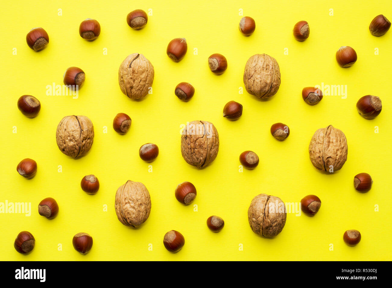 Christmas background of walnuts and hazelnuts. Yellow background Flat ...