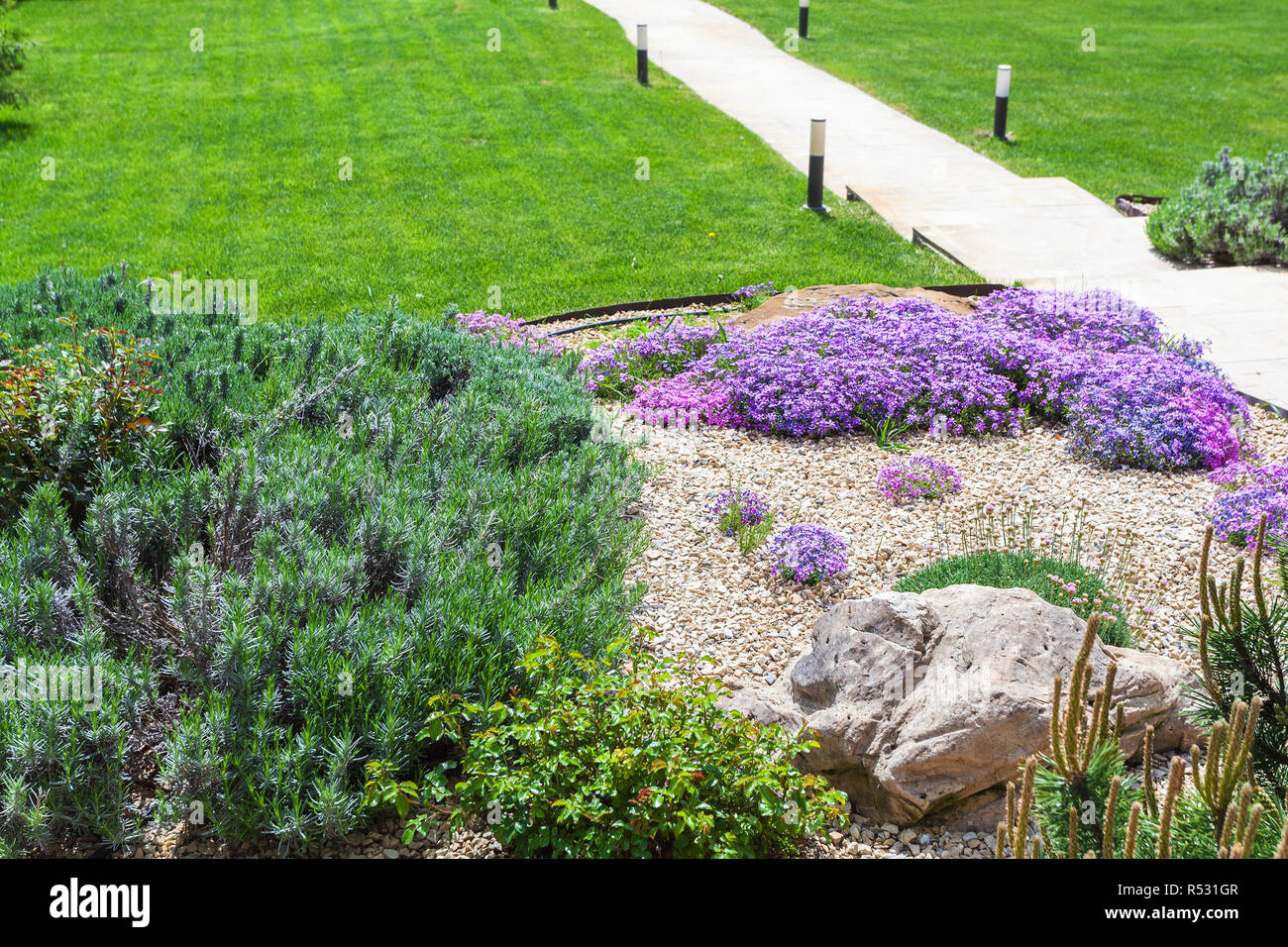 alpine garden and sloped lawn with path Stock Photo - Alamy