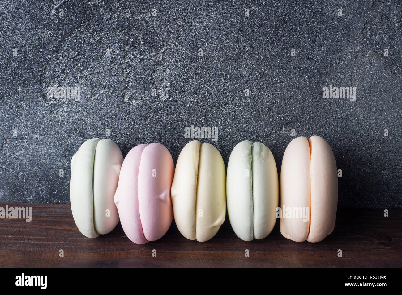 Large round marshmallows of different colors on the table with copy ...