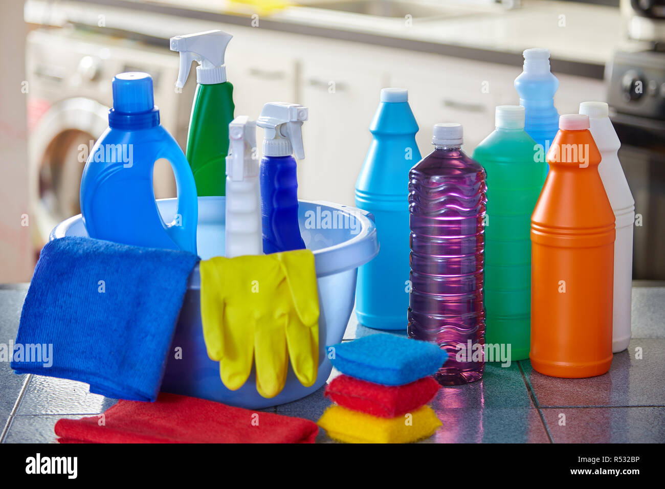 Household cleaning items in basket on kitchen table with blurred ...