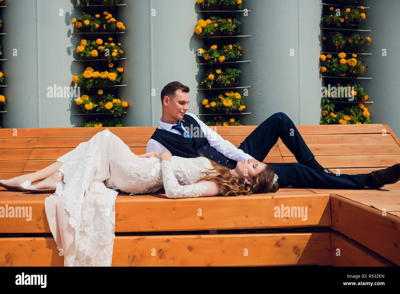 two lovers sit on a bench, newlyweds crouched to rest in each other's ...