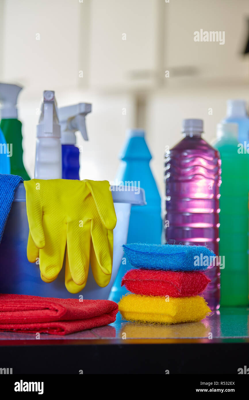 Household cleaning items in basket on kitchen table with blurred ...