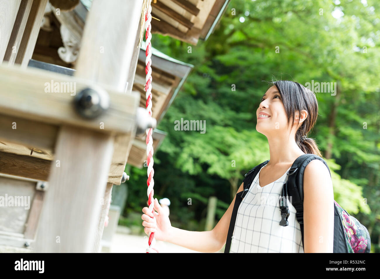 Woman ringing the bell in Japanese temple Stock Photo - Alamy