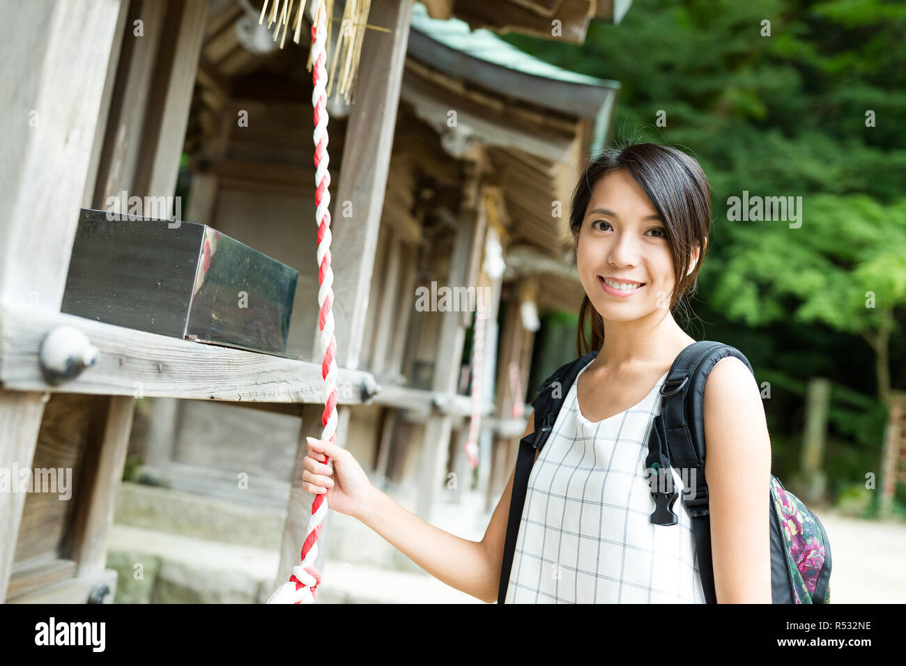 Woman ringing the bell in Japanese temple Stock Photo - Alamy