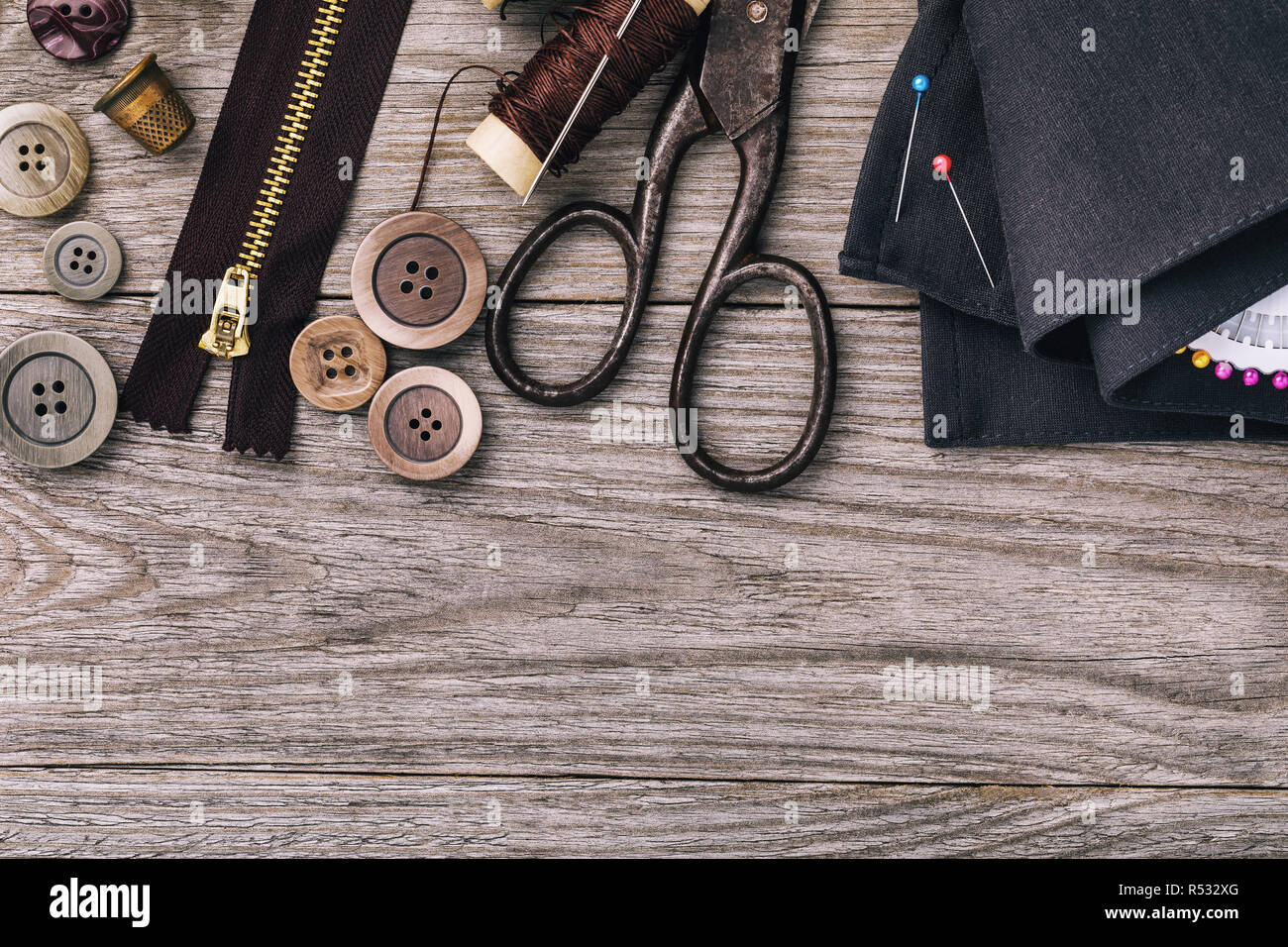 Tools for repairing clothes on wooden table with copy space, top view ...