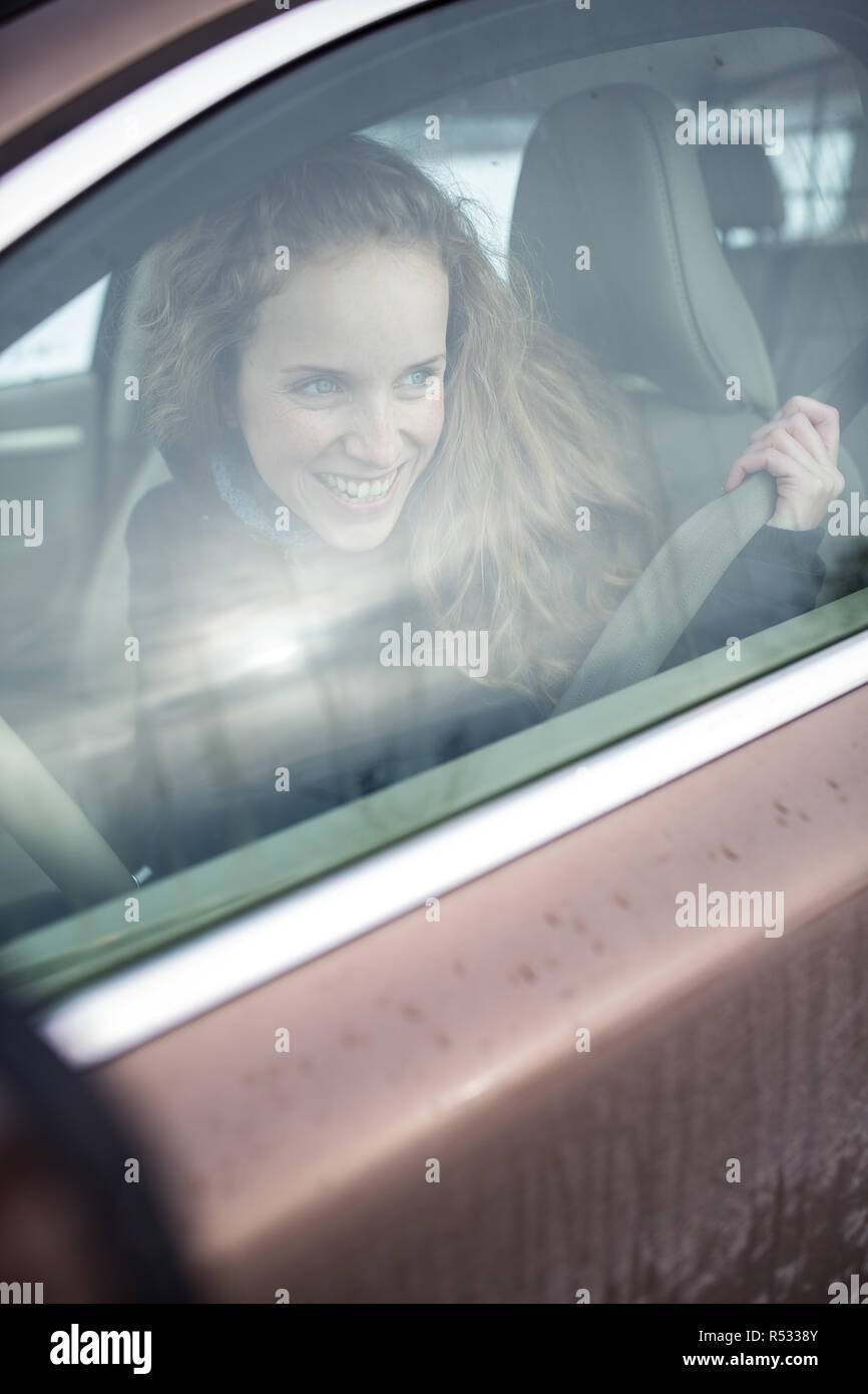 Woman driving a car - female driver at a wheel of a modern car, looking ...