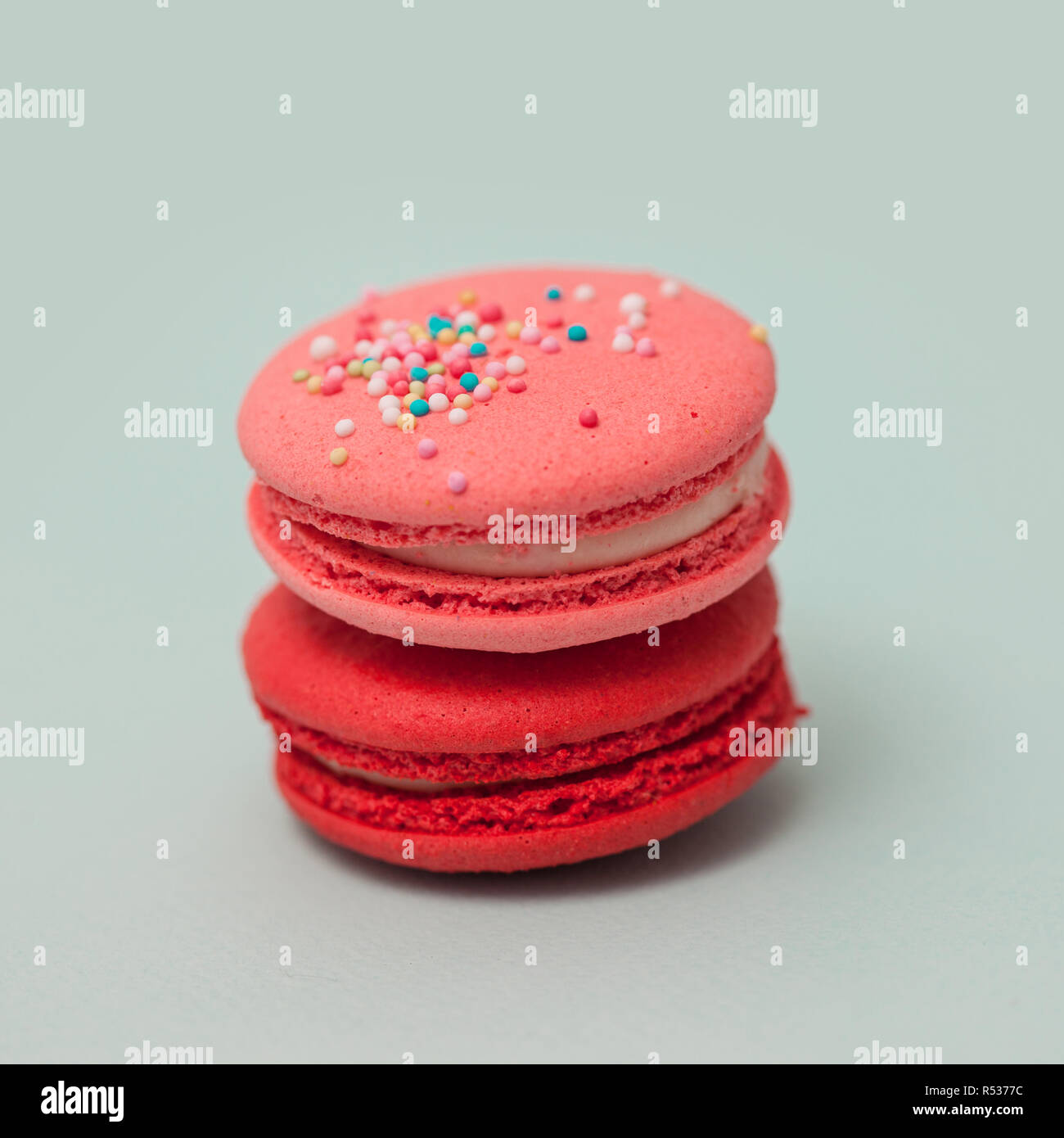 Bright delicious macaroons. French sweets. Pink cake on light blue ...