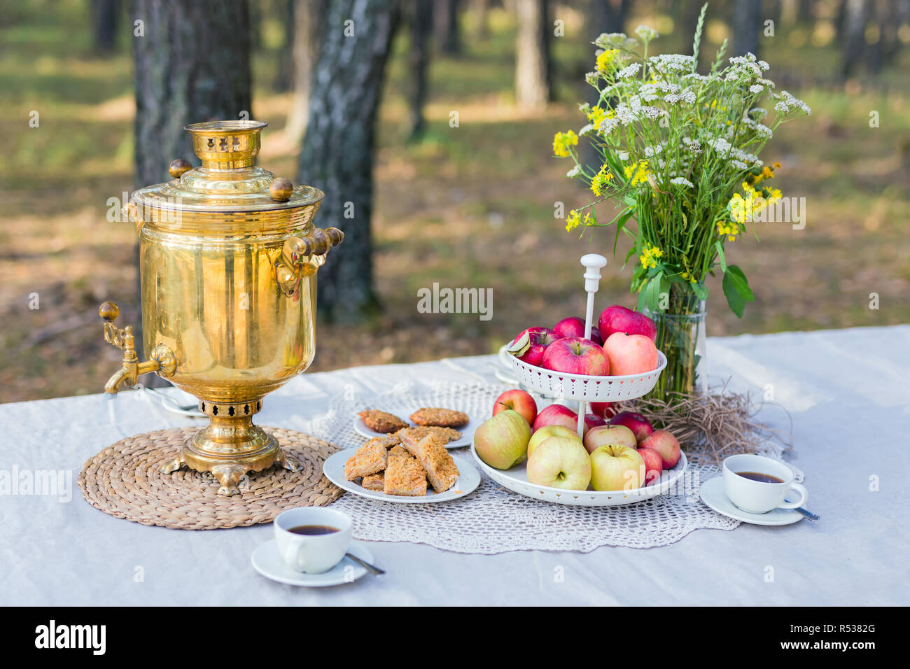 Traditional samovar on a table with snacks and field flowers bouquet ...