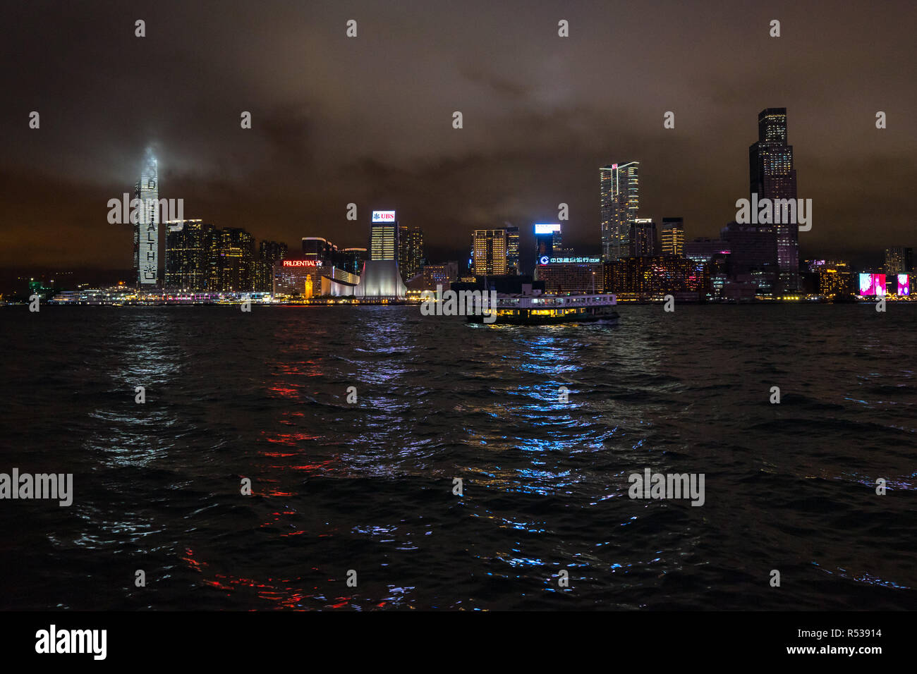 Kowloon skyline at night with Star Ferry crossing Victoria Harbour ...