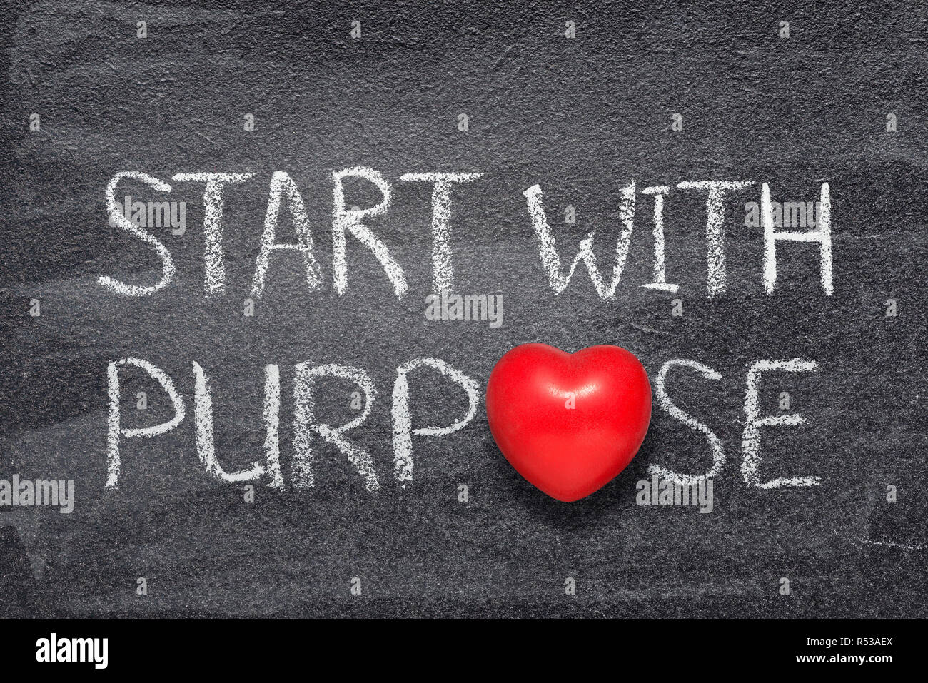start with purpose phrase handwritten on chalkboard with red heart ...