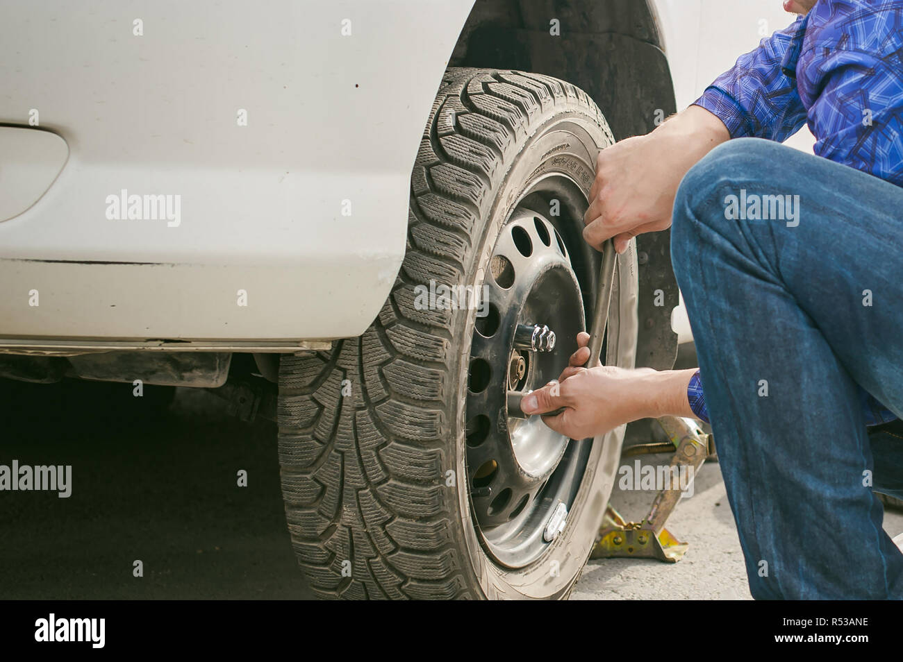 man changing a wheel on the road. on way there was breakage of wheel ...