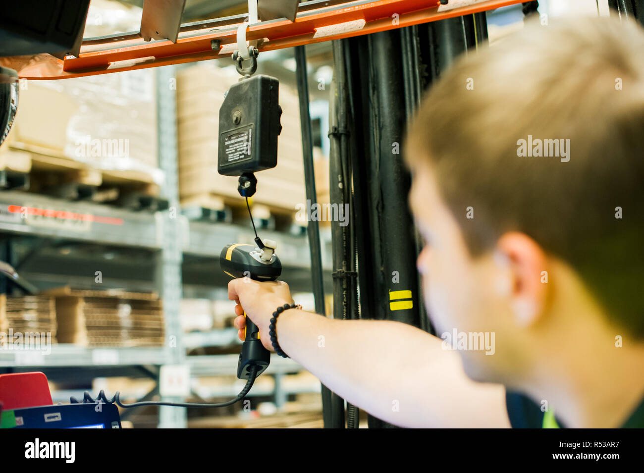 young man in working clothes, driver Reachtruck busy working on the ...