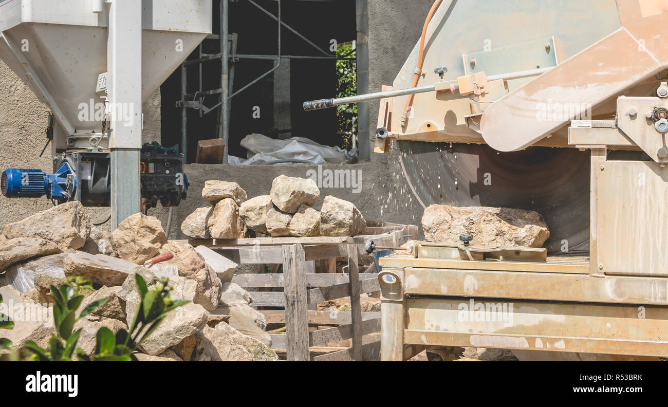 man cutting a stone with a water saw Stock Photo - Alamy