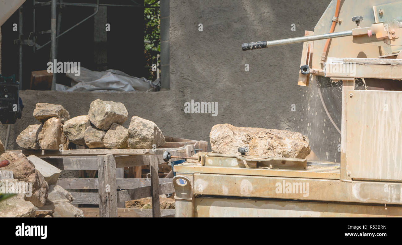 man cutting a stone with a water saw Stock Photo - Alamy