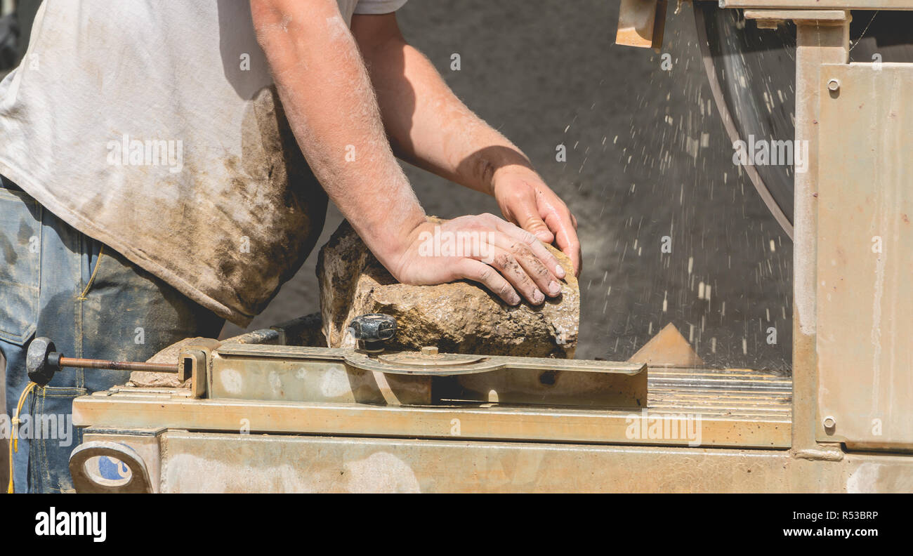 man cutting a stone with a water saw Stock Photo - Alamy