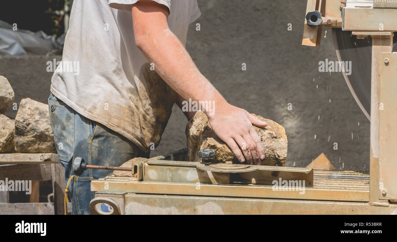 man cutting a stone with a water saw Stock Photo - Alamy