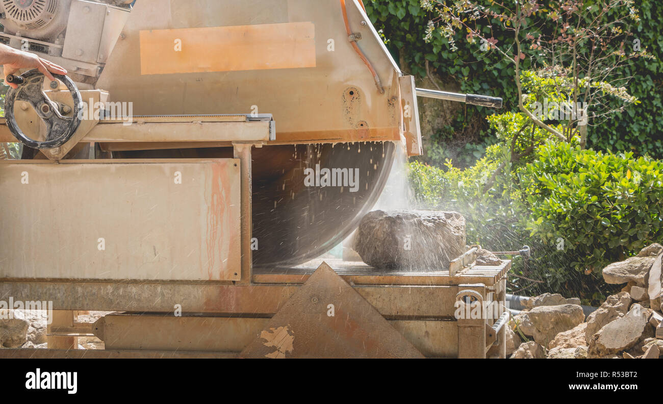 man cutting a stone with a water saw Stock Photo - Alamy