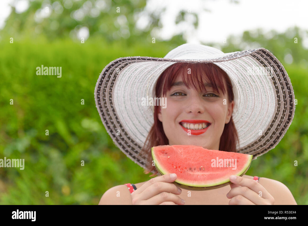 Beautiful girl eating a watermelon Stock Photo - Alamy
