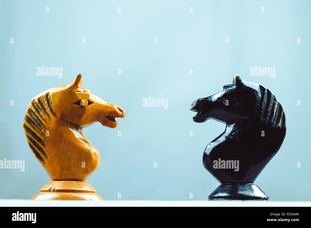 Chess knights face to face on grey background Stock Photo - Alamy