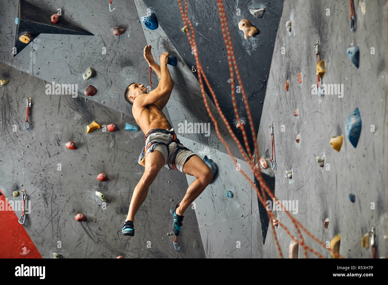 Panoramic man bouldering at an indoor climbing centre Stock Photo - Alamy