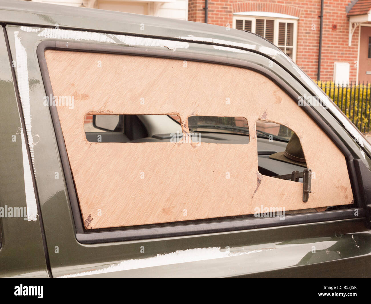 a car window boarded up with wood panel outside Stock Photo - Alamy