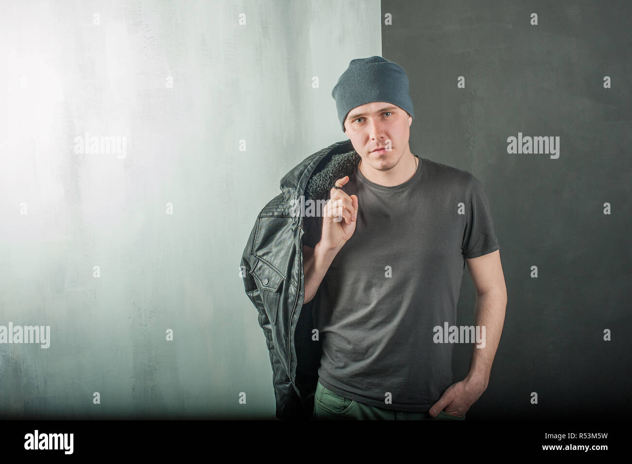 studio photography young brutal guy. man in T-shirt, jeans and a ...
