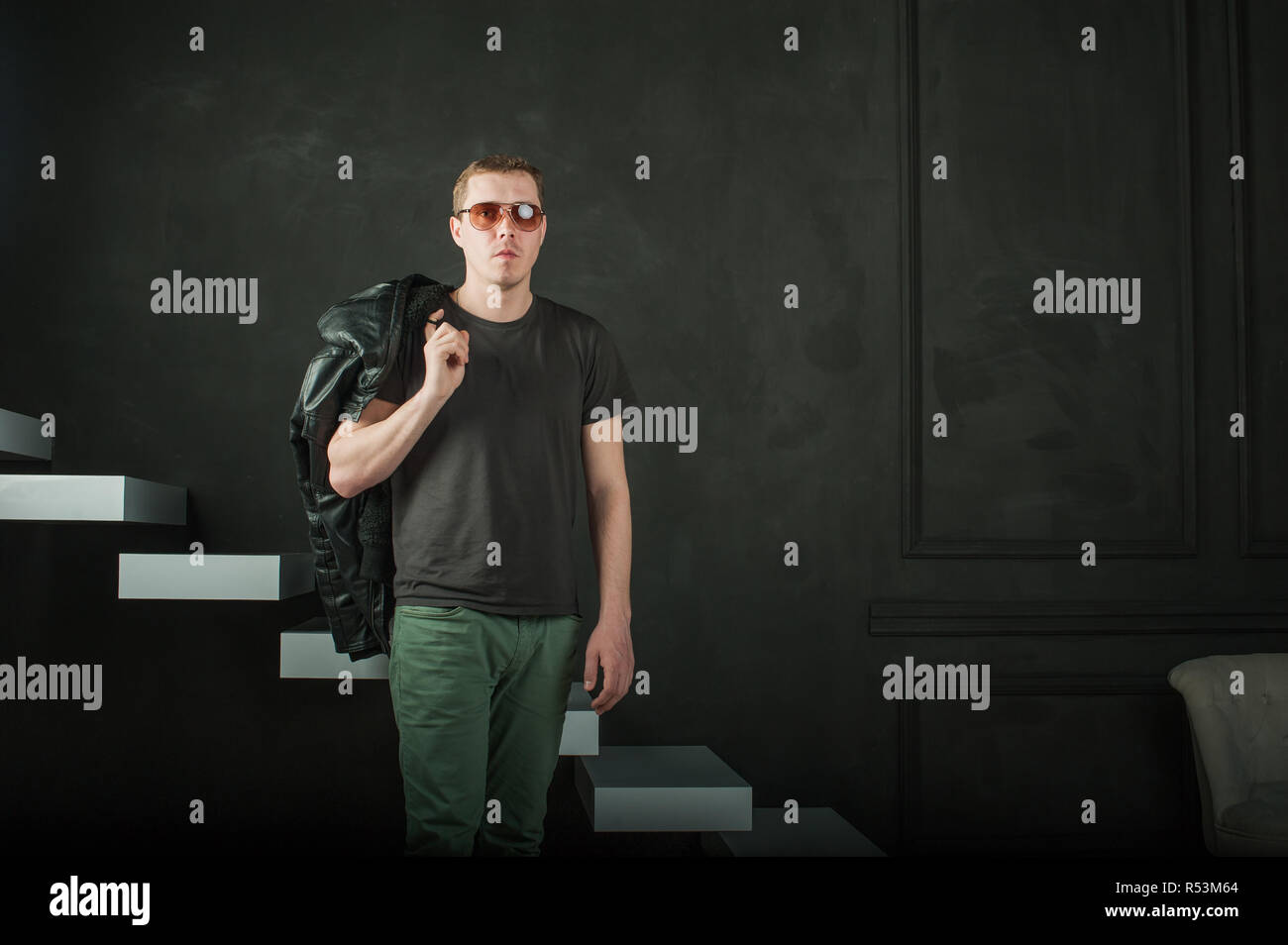 studio photography young brutal guy. man in sunglasses, T-shirt, jeans ...