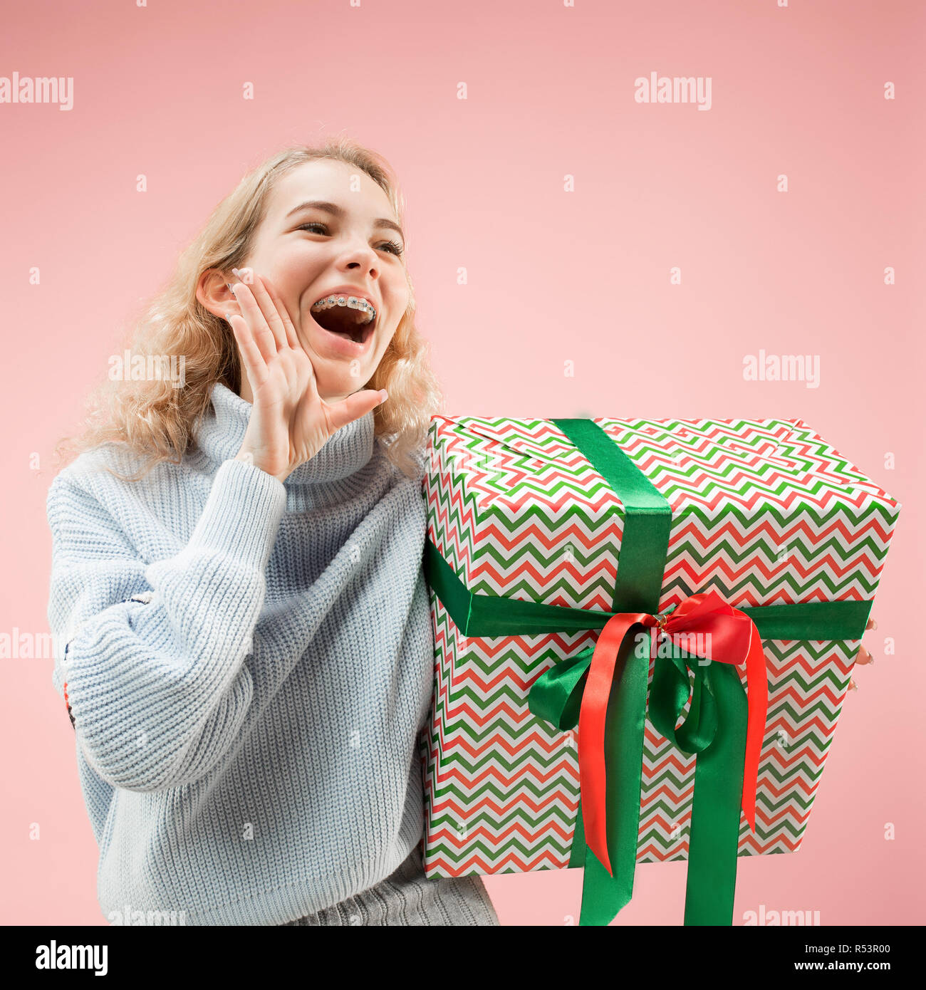 The surprised woman with big colorful gift box. Soft colors. Christmas ...
