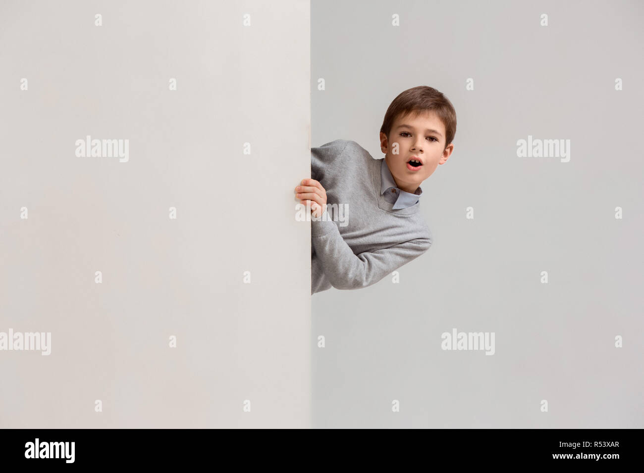 Banner with a surprised child peeking at the edge at studio Stock Photo ...