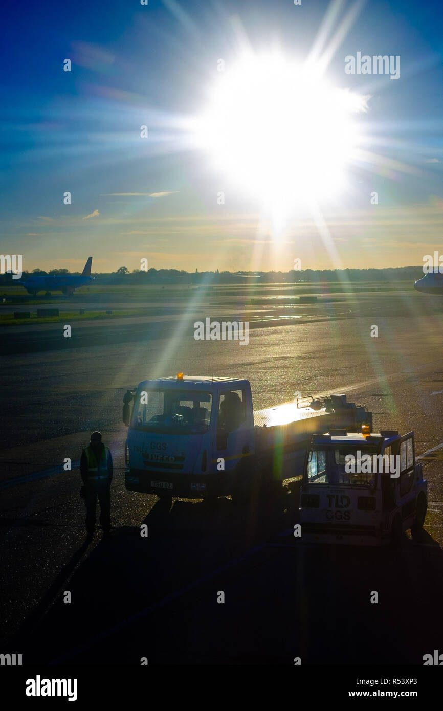 The sun shines over a refuelling tug on the airport apron at Gatwick ...