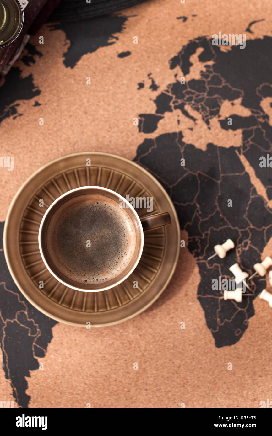 A cup of aromatic coffee on the map and accessories for travel. Vintage ...