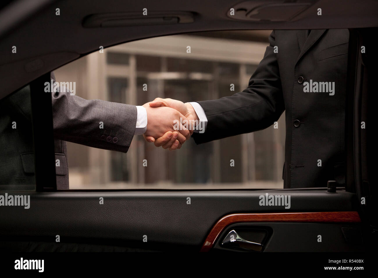 Two businessmen shaking hand through car window Stock Photo - Alamy